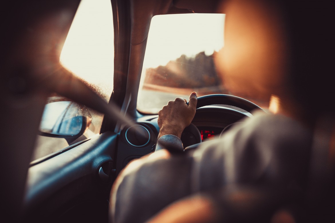Man driving car, hand on steering wheel, looking at the road ahead ...